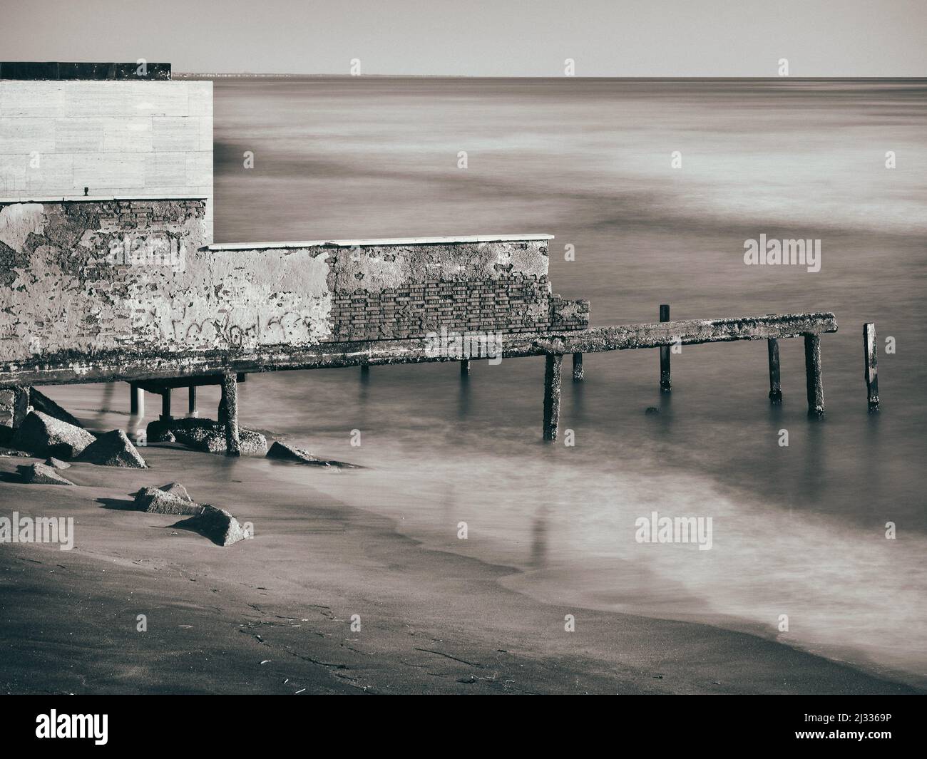A greyscale shot of an abandoned old structure on the sea Stock Photo ...
