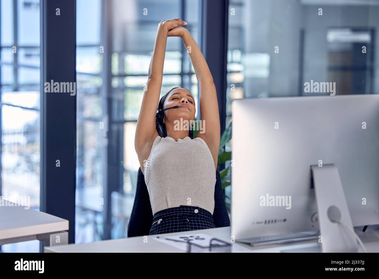 Stretching out the stiffness. Shot of a female center worker taking a ...