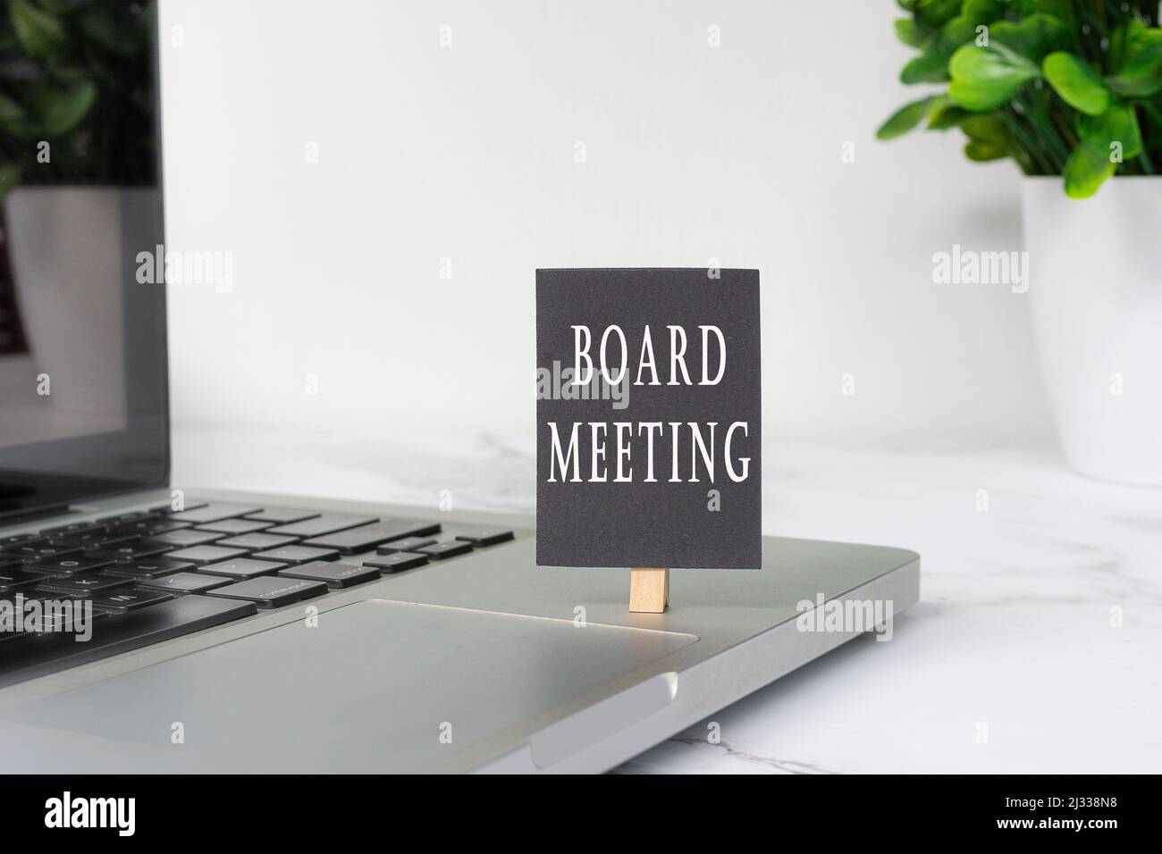 Board meeting text on chalkboard placed on laptop or notebook. Business ...