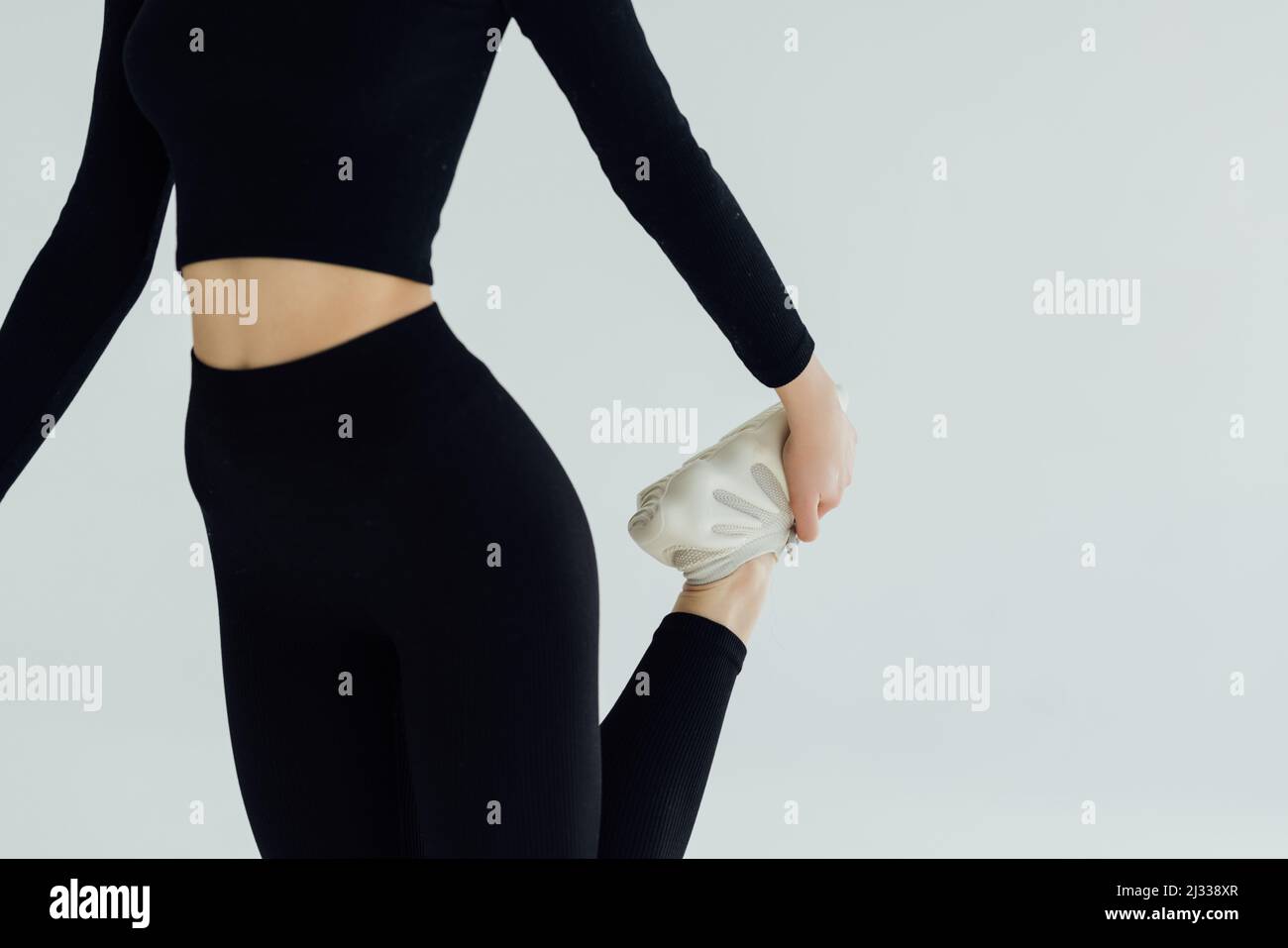 Side view portrait of a young fitness woman standing and stretching ...