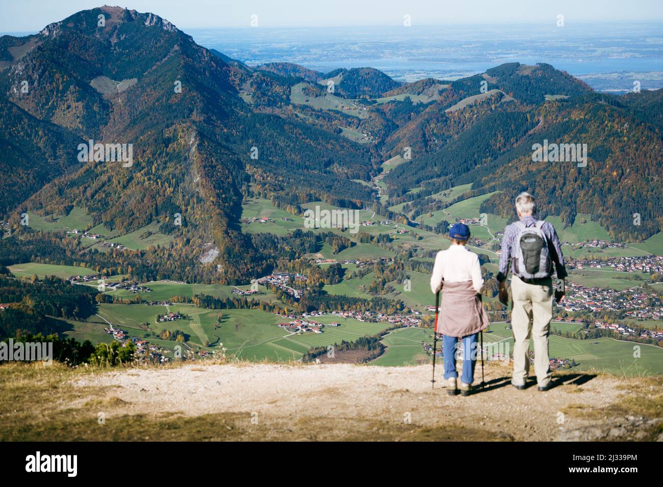 Two hikers on the summit look into the autumn valley Stock Photo - Alamy