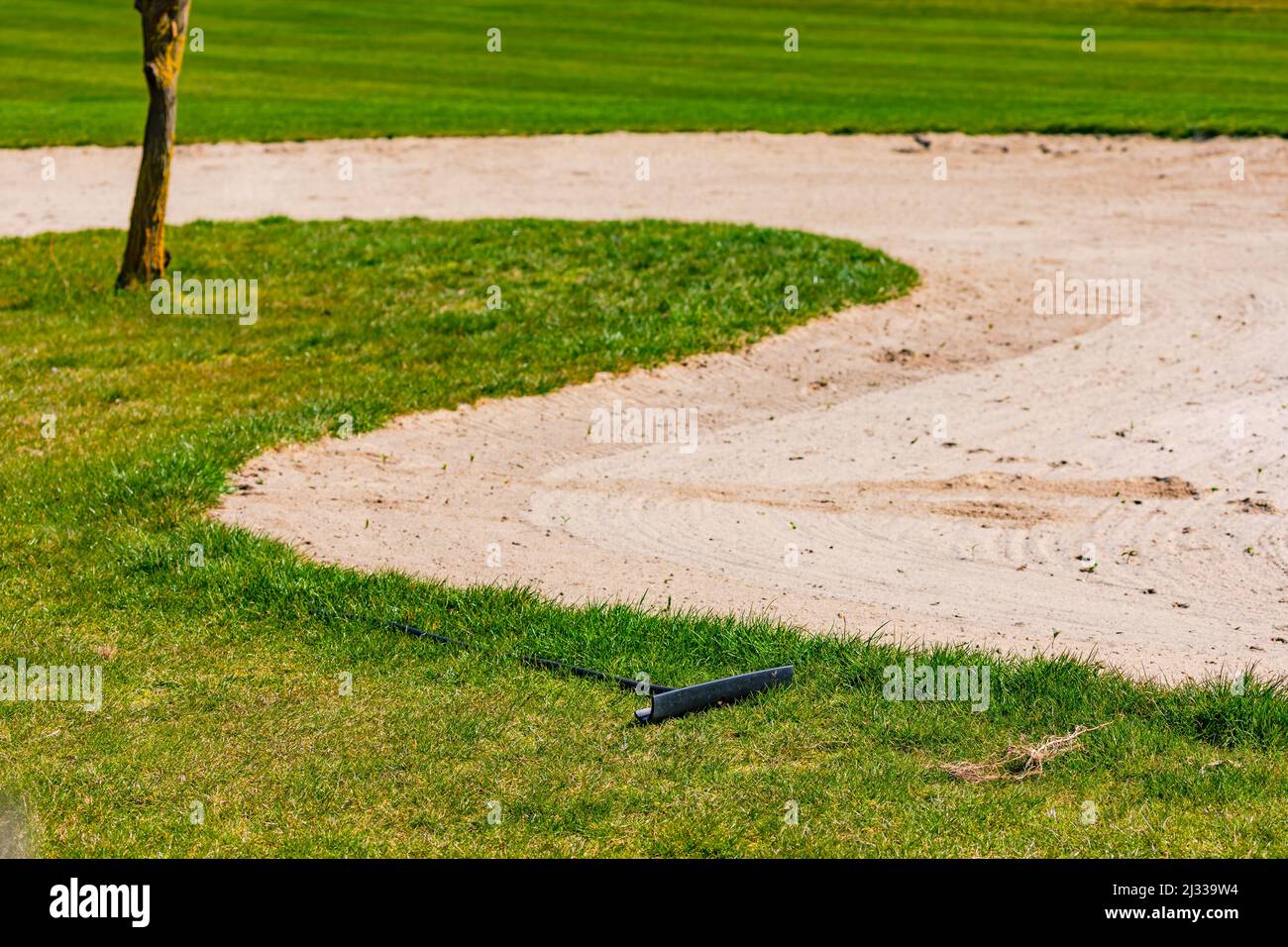 A rake on a bunker with sand is used to remove tracks on the luxury ...