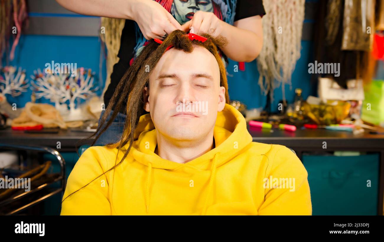 Professional hairstylist makes brown dreadlocks for client Stock Photo ...