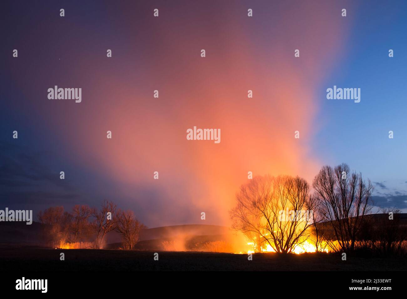 Fire at night, burning the farm at night, smoke rising into the air ...