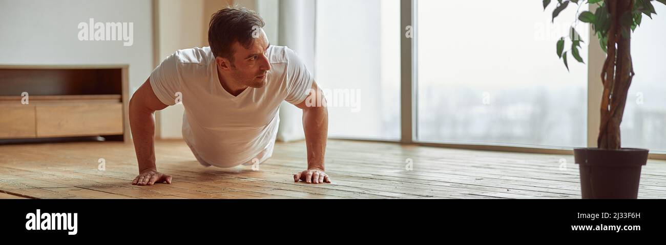Strong man doing plank at home alone Stock Photo - Alamy