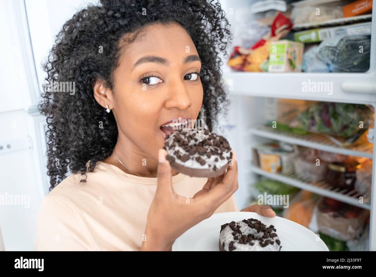 Young woman tempted junk food hi-res stock photography and images - Alamy