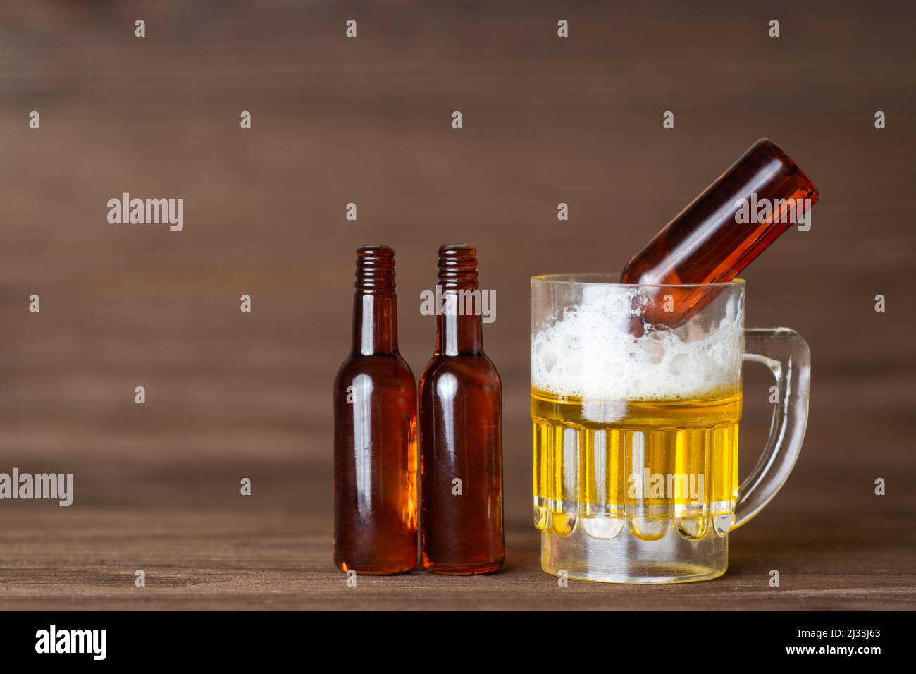 Empty beer bottles standing by a miniature beer mug. Moderate alcohol ...