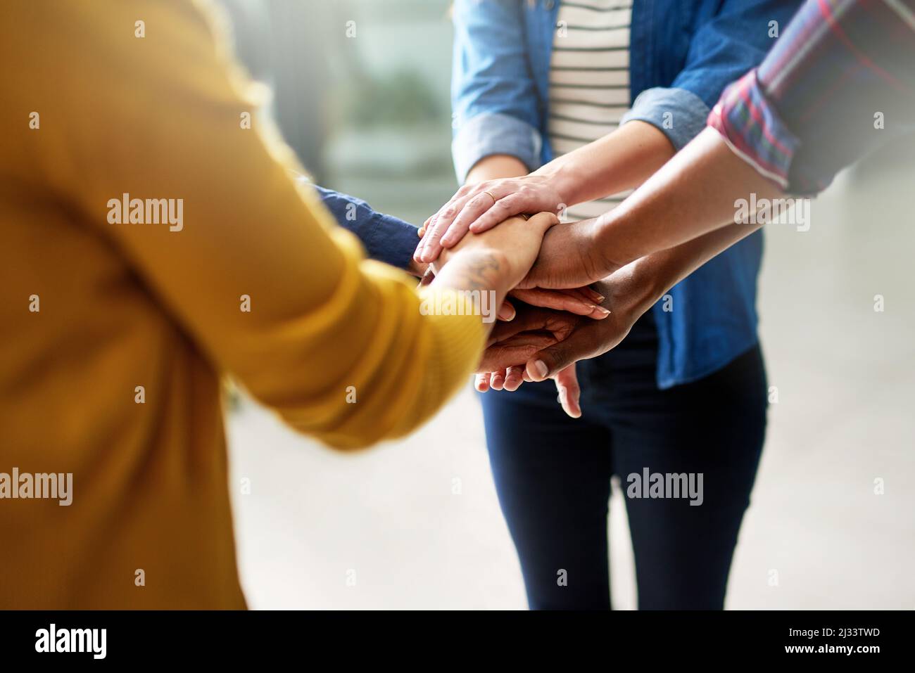 Team motivation will drive them to success. Closeup shot of a group of businesspeople joining ...
