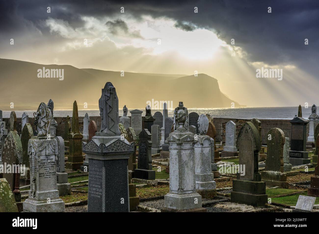 Clusters of rays, dramatic sky over Stromness Cemetery, Orkney, looking ...