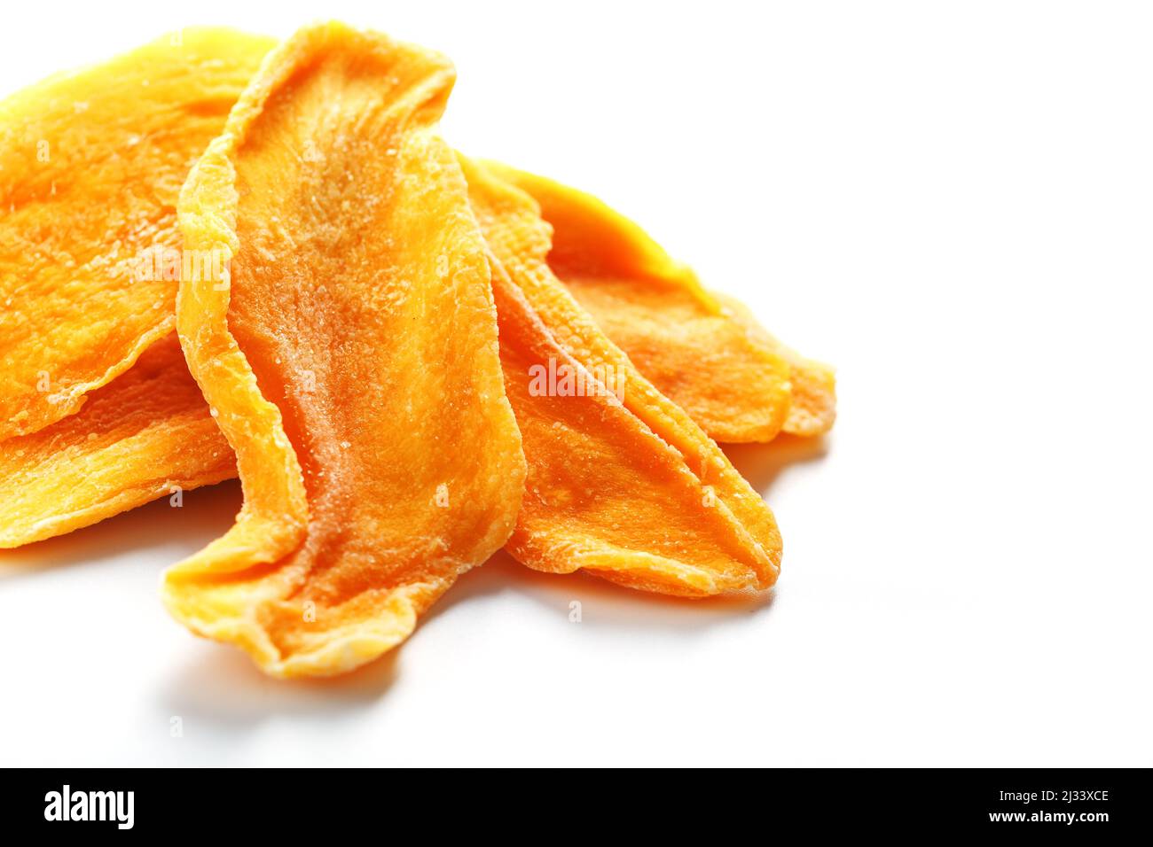 Dried sweet mango fruit slices as textural orange background in full ...