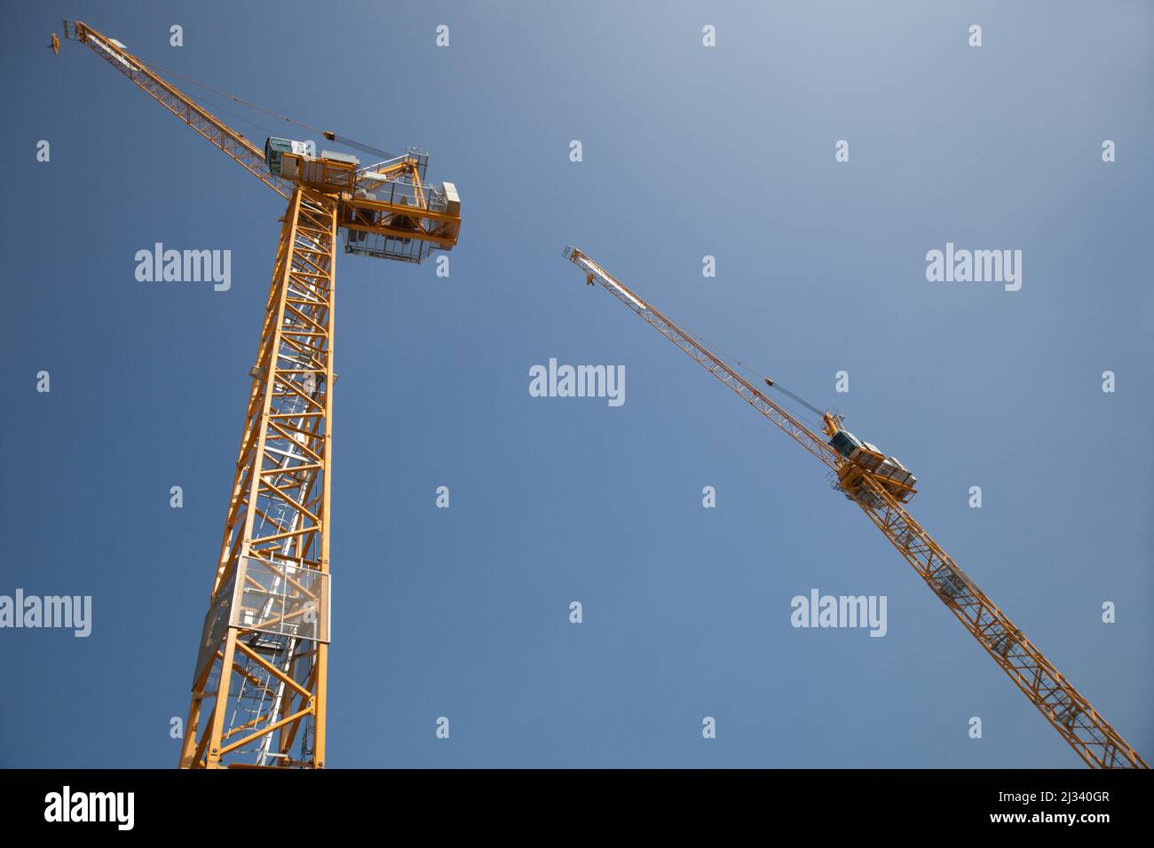 Two cranes working in tandem on a construction site in the UK Stock ...