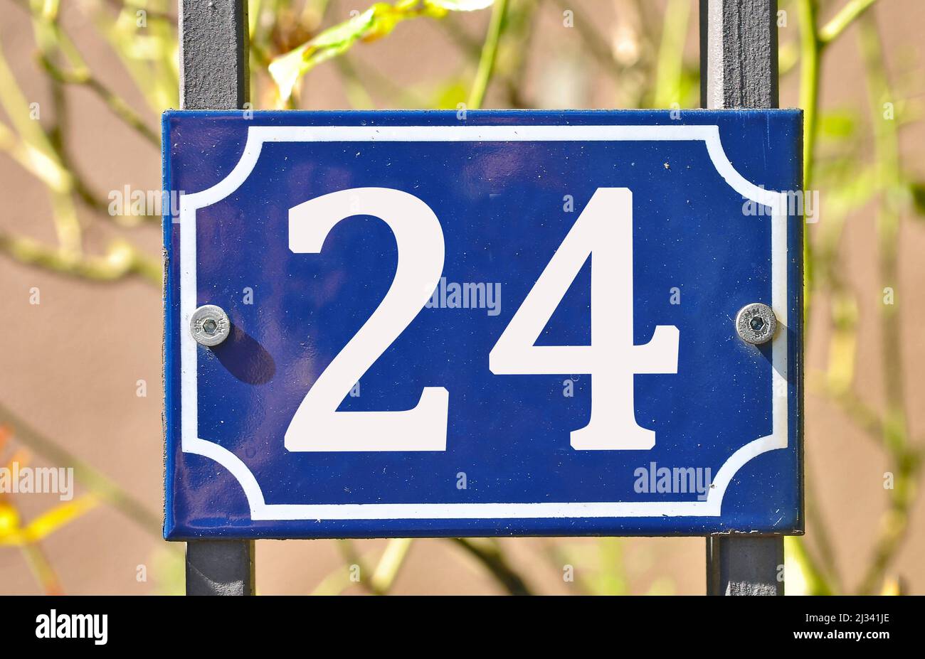 A closeup shot of a blue sign with the number "24" on the blurry ...