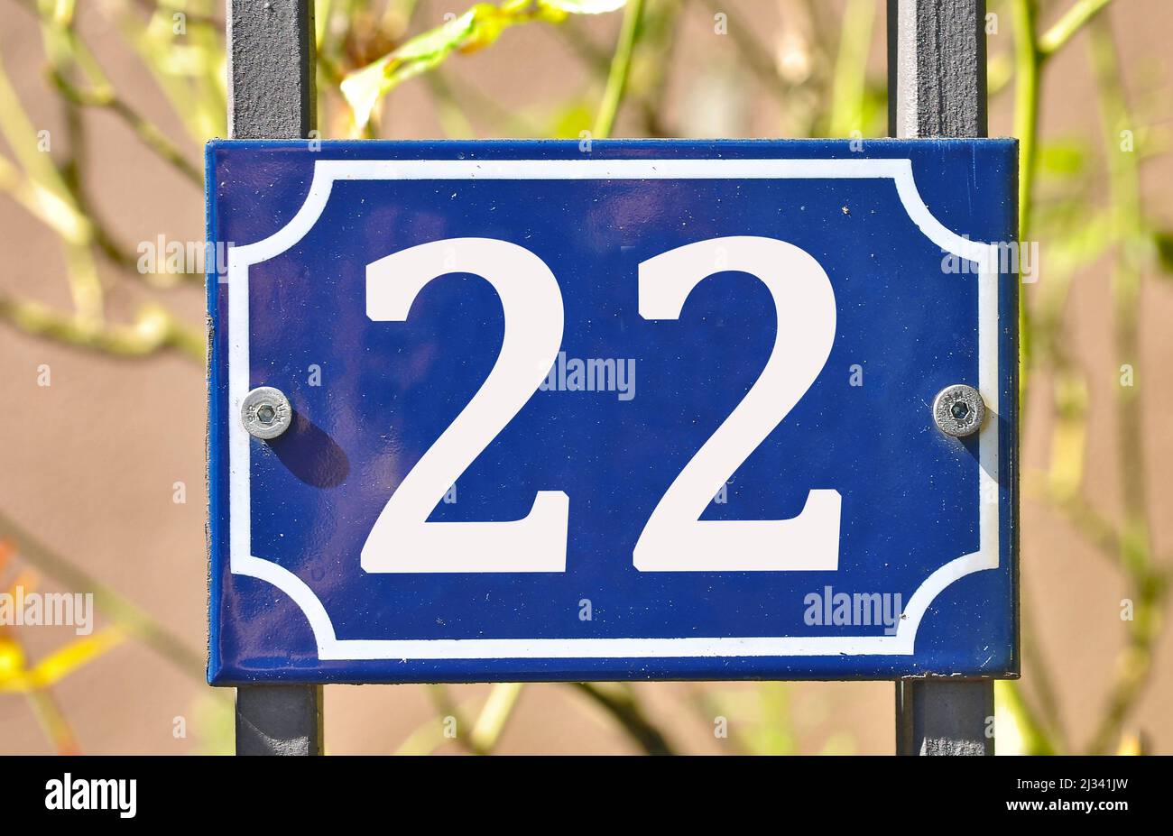 A closeup shot of a blue sign with the number "22" on the blurry ...