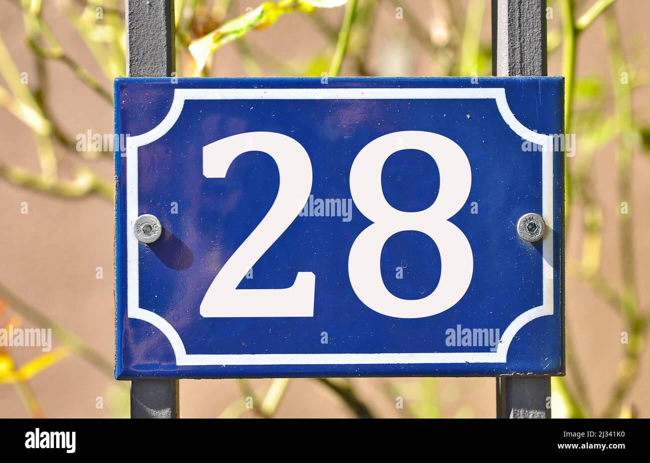 A closeup shot of a blue sign with the number "28" on the blurry ...