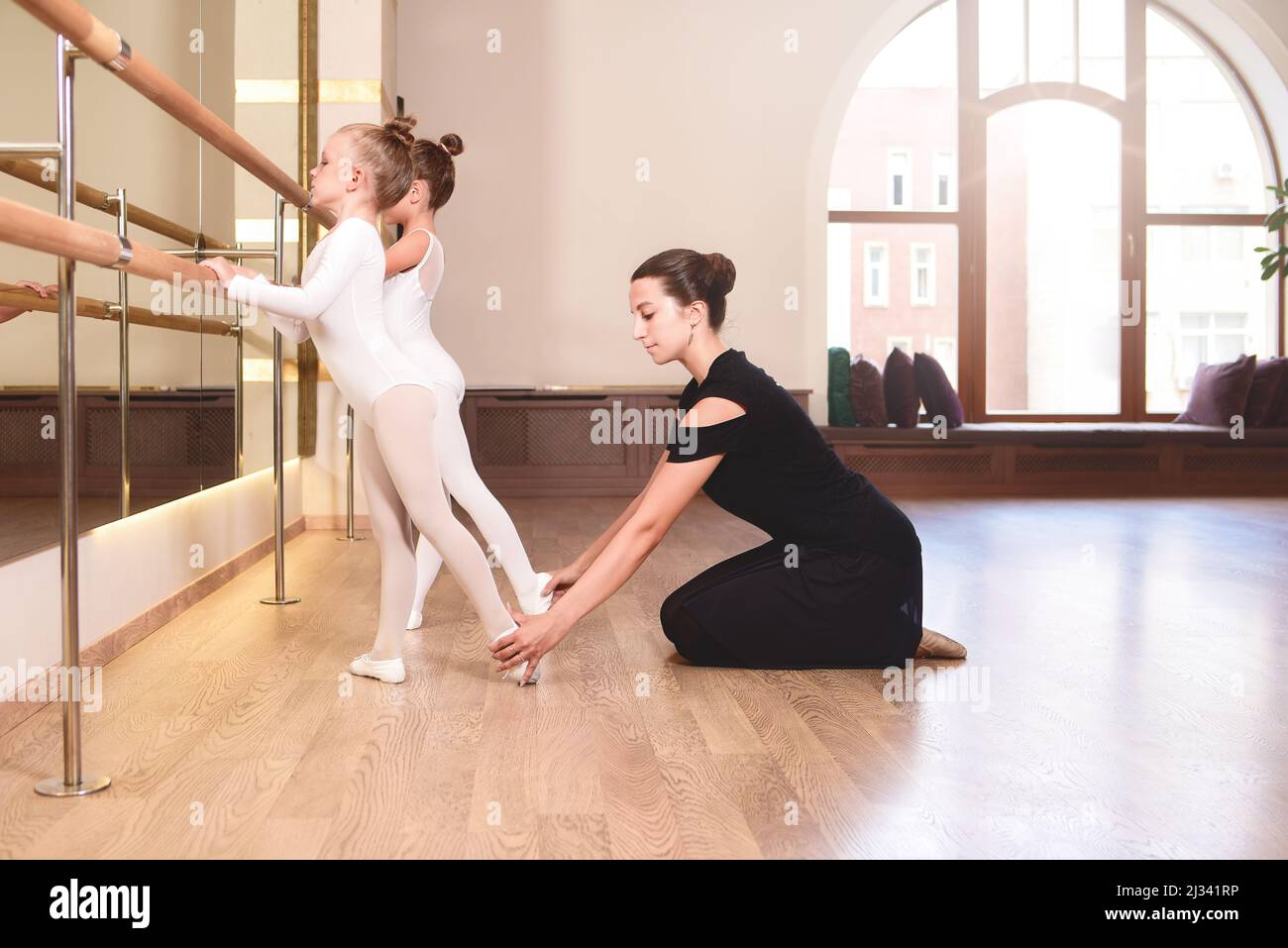 Female dance instructor trying to comfort one of her little students ...