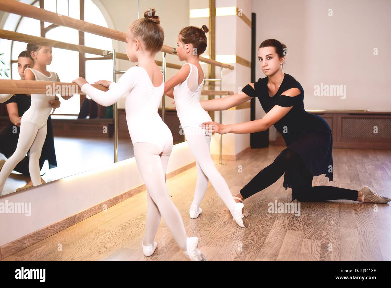 Female dance instructor trying to comfort one of her little students ...