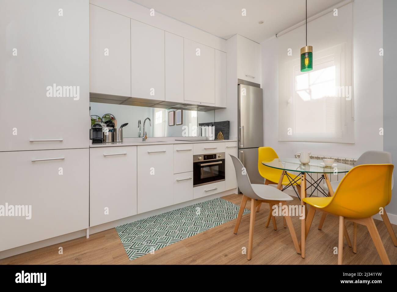 Kitchen open to living room with white cabinets and white stone ...