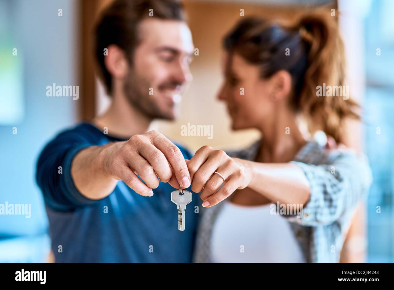 The keys to our new home. Shot of a cheerful young couple holding a key ...