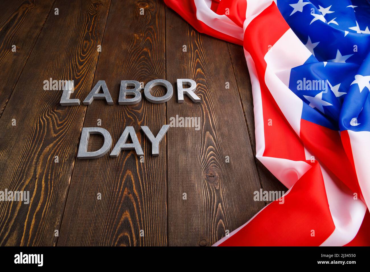 words labor day laid with silver metal letters on wooden surface with ...