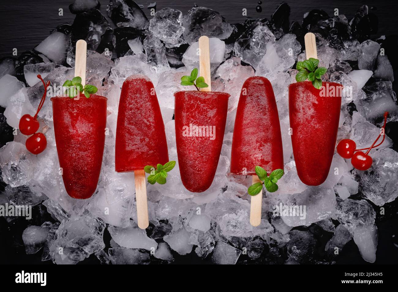Fruit cherry ice lolly on a black background Stock Photo - Alamy