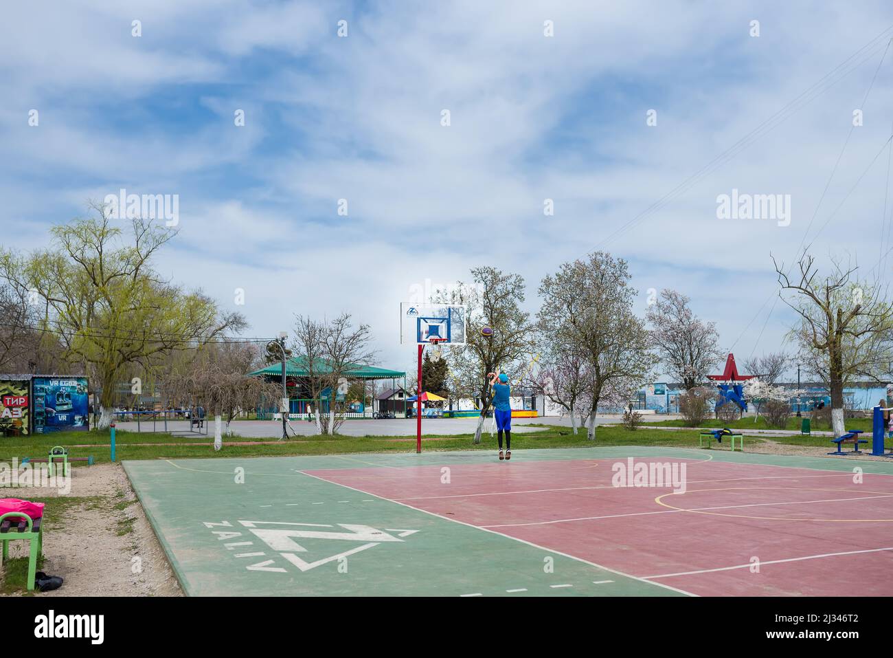Boy On Basketball Court Shooting For Basket, spring time in park Stock ...