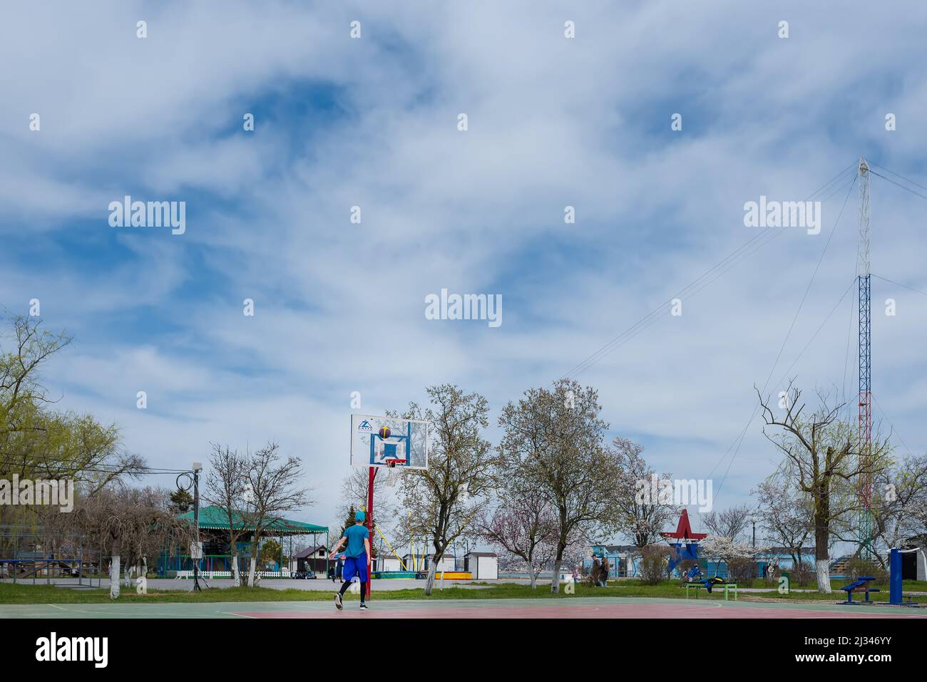 Boy On Basketball Court Shooting For Basket, spring time in park Stock ...