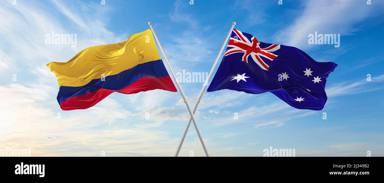 two crossed flags Colombia and Australia waving in wind at cloudy sky ...