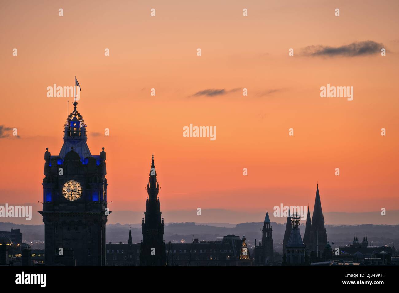 Sunset sky over Edinburgh with the city's towers and rooftops. Blue ...