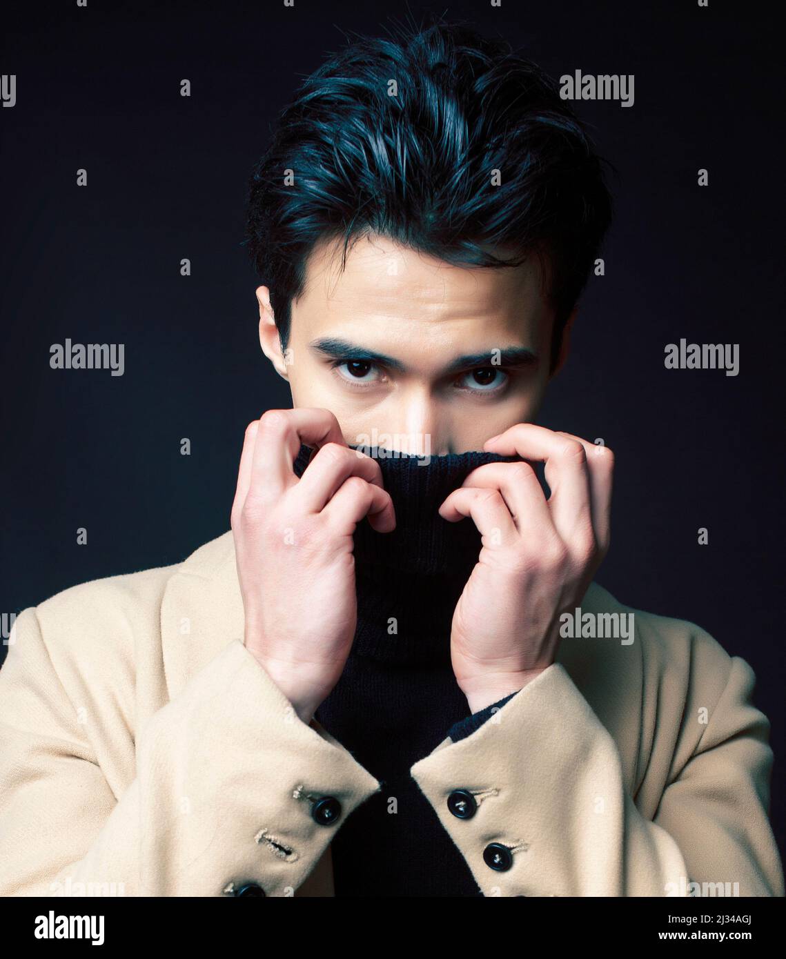 handsome asian fashion looking man posing in studio on black background ...