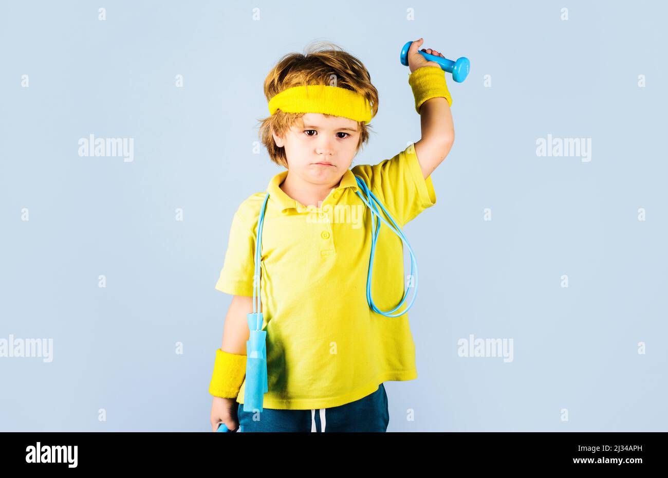 Sporty child with skipping rope and dumbbells. Kid boy sportsman with ...
