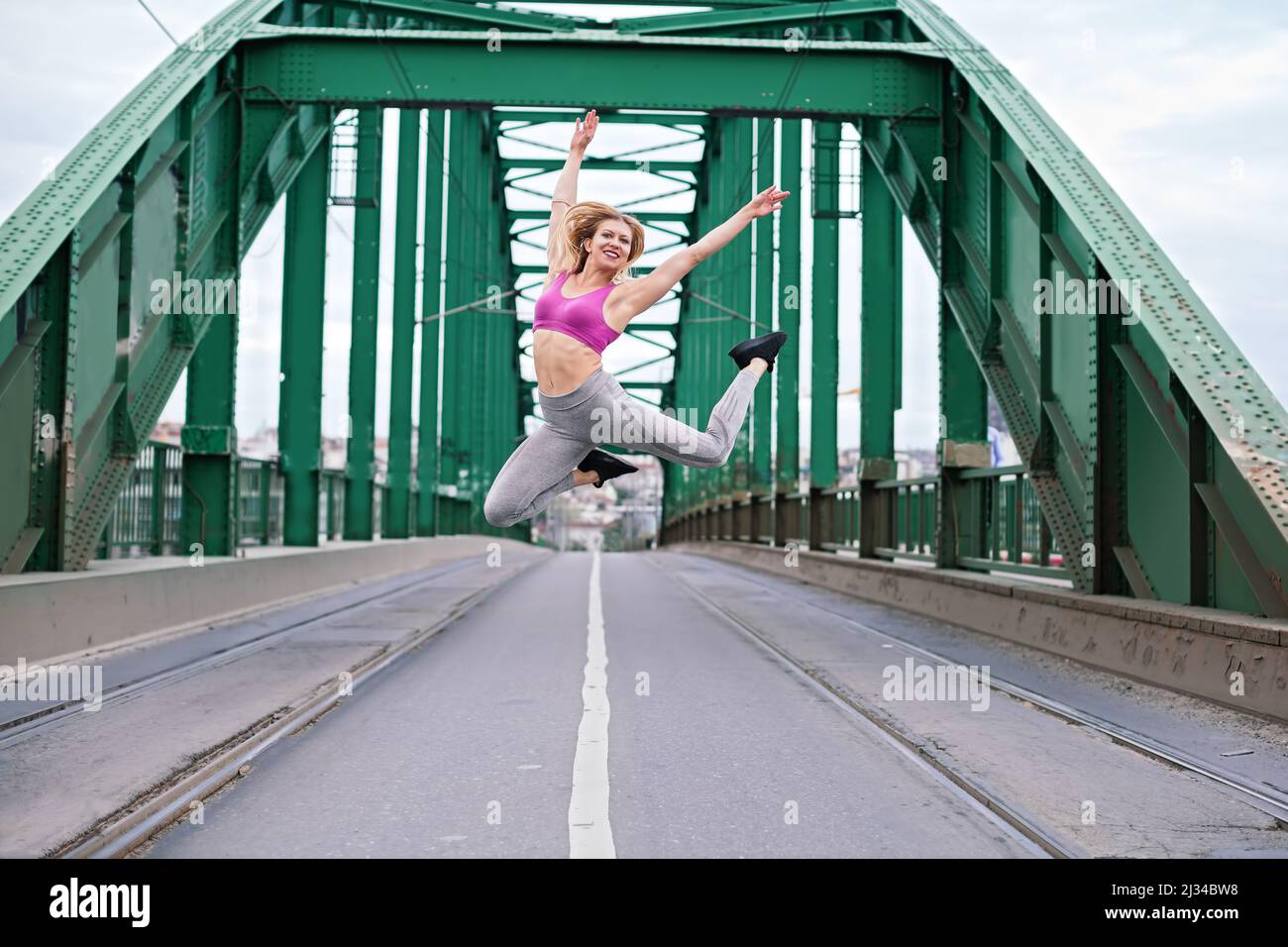 young woman jumping high at the bridge Stock Photo - Alamy