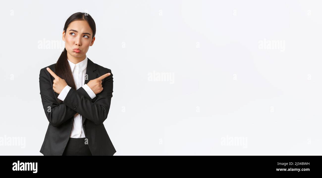 Puzzled pretty asian businesswoman in black suit troubled making choice ...