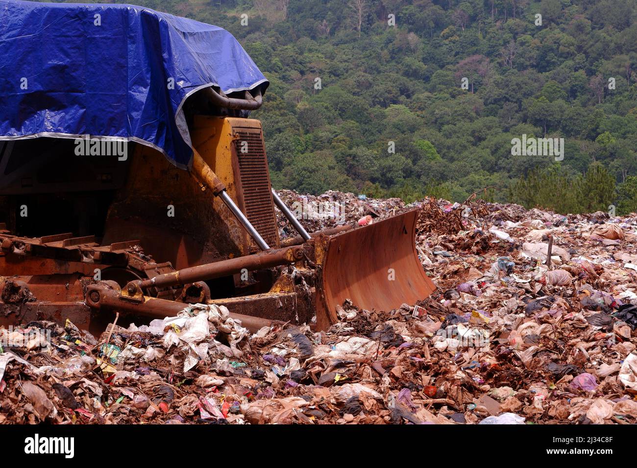 A large dump of garbage with the garbage collection machine Stock Photo ...