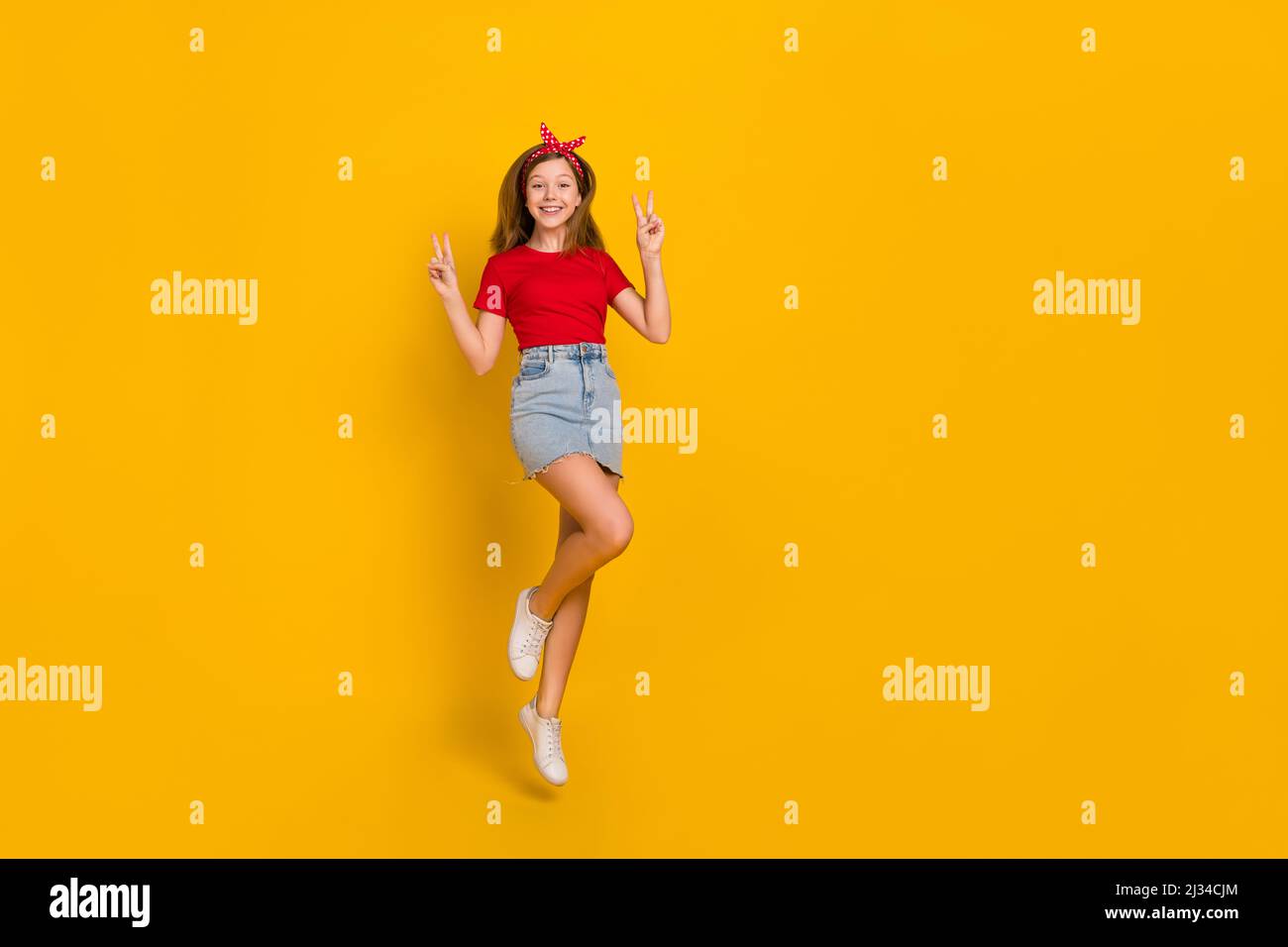 Full length photo of funny little girl jump show v-sign wear red t ...