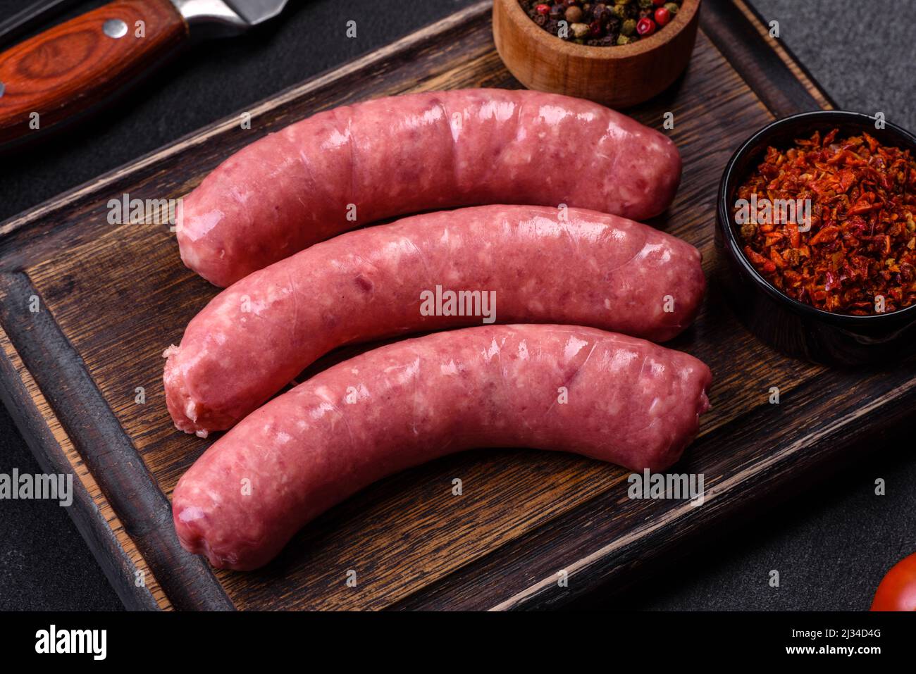 Raw barbecue sausages with spices and vegetables. Free space for your ...