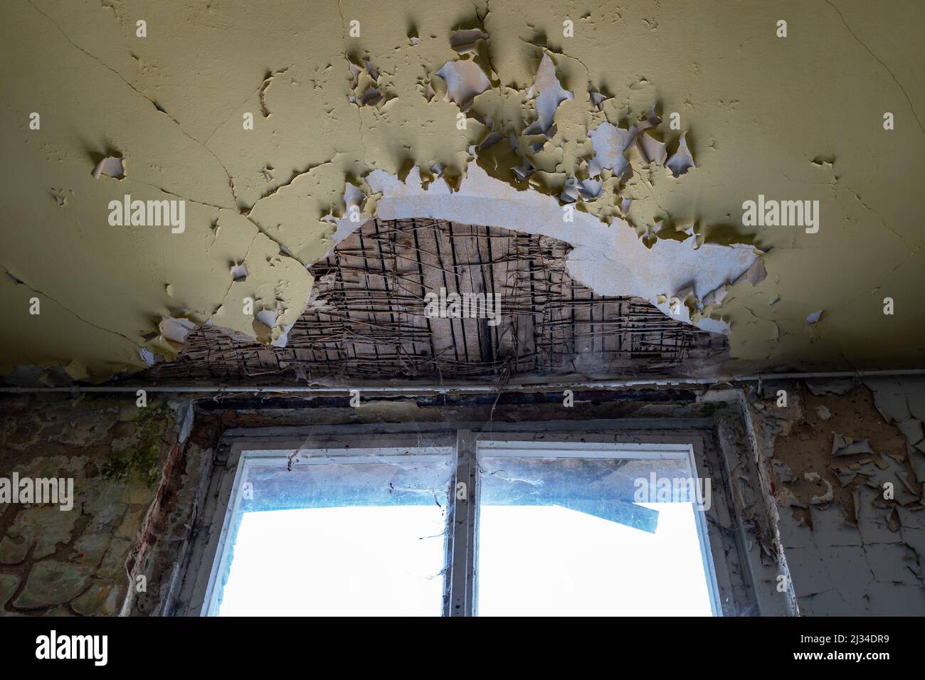 Damaged ceiling on top of a window. Eroded building structure and paint ...