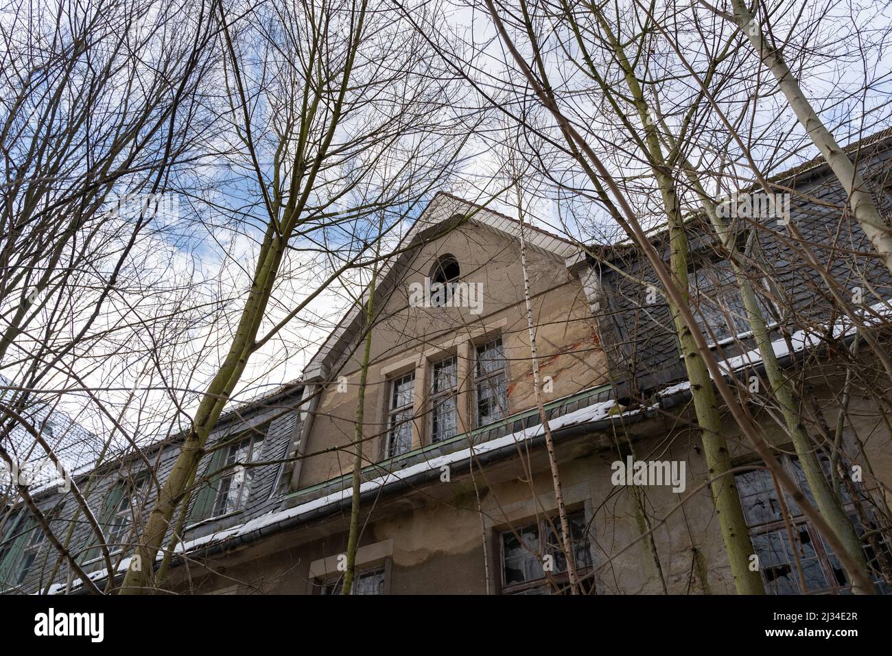 Abandoned building with a damaged facade and broken windows. Looking up ...