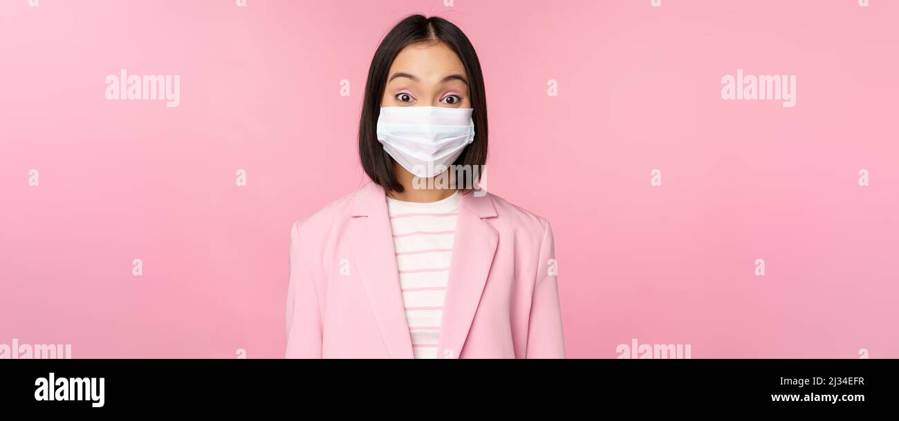Portrait Of Asian Businesswoman In Medical Face Mask Wearing Suit