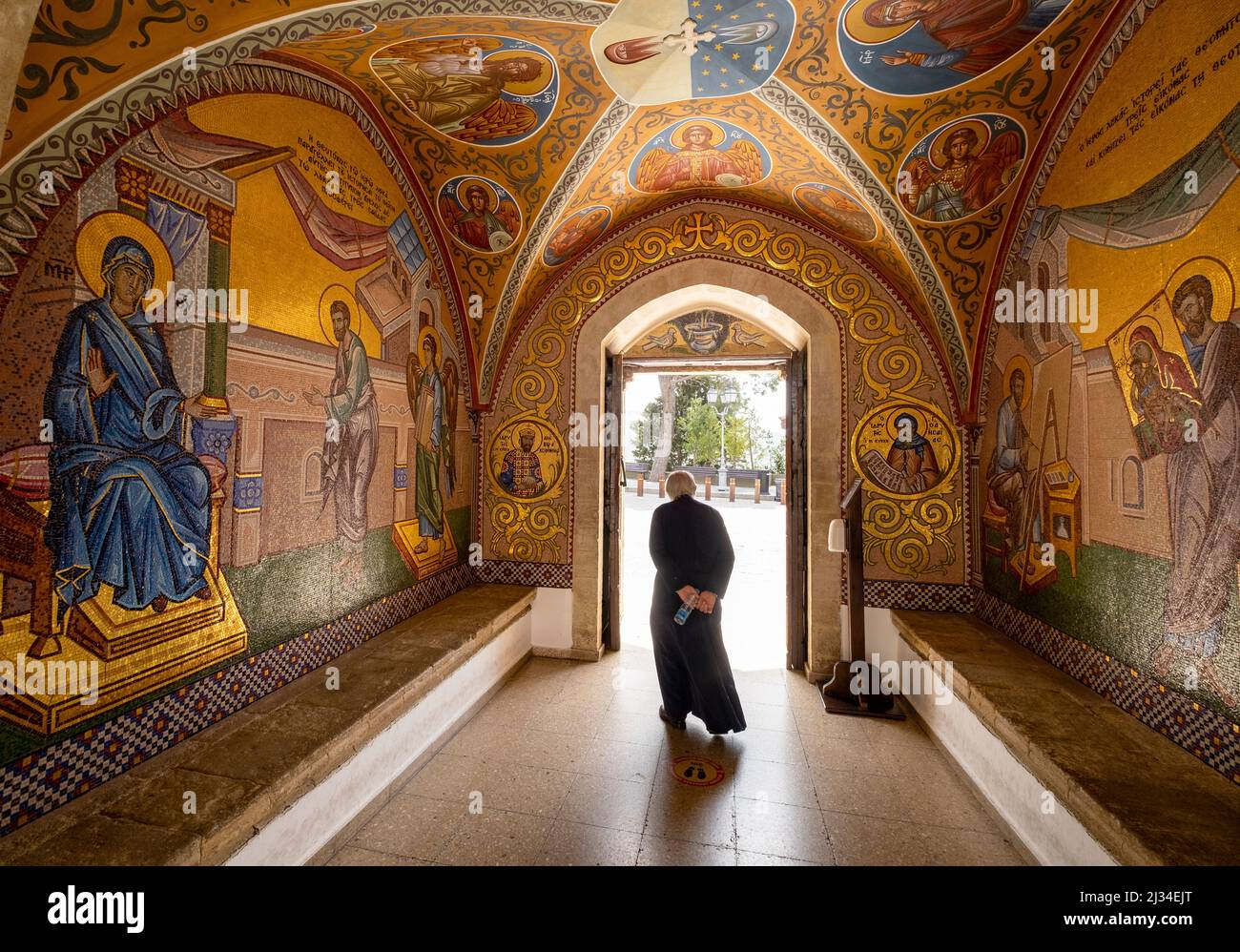 A monk walks through the entrance of the Kykkos Monastery which is ...