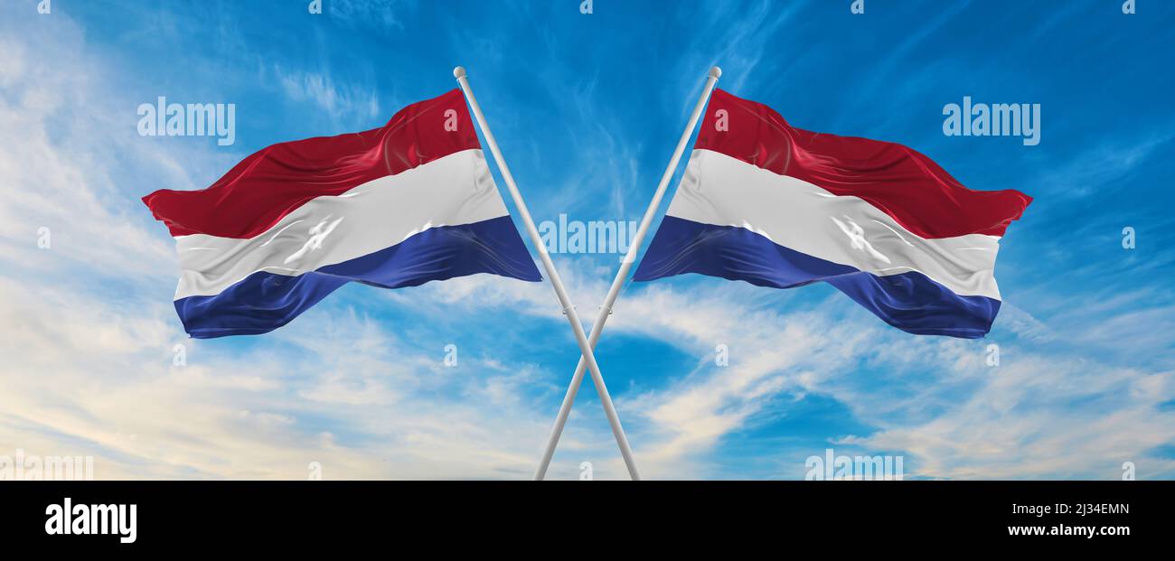 two crossed flags netherlands and Netherland waving in wind at cloudy ...