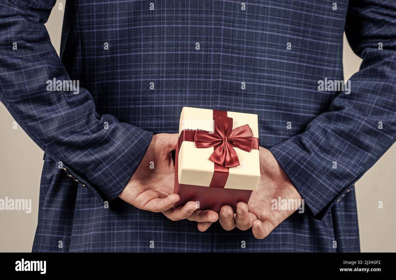 Present box in male hands behind back, boxing day Stock Photo - Alamy