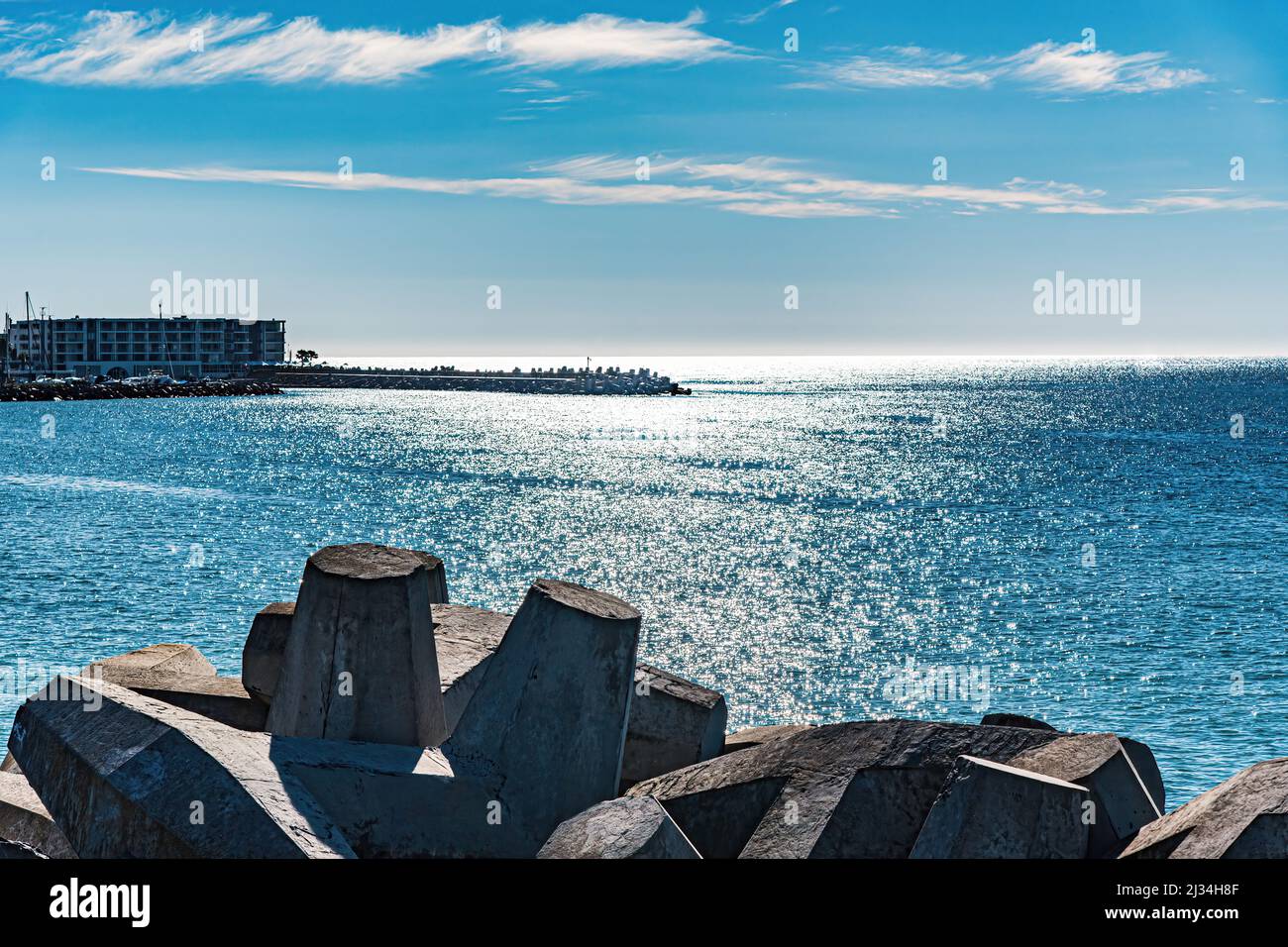 An ocean coast with concrete blocks in background of buildings in Cape ...