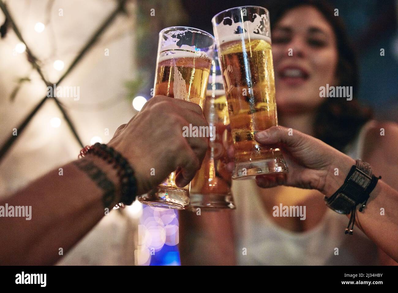 Cheers to great friends. Cropped shot of three friends having beers in ...