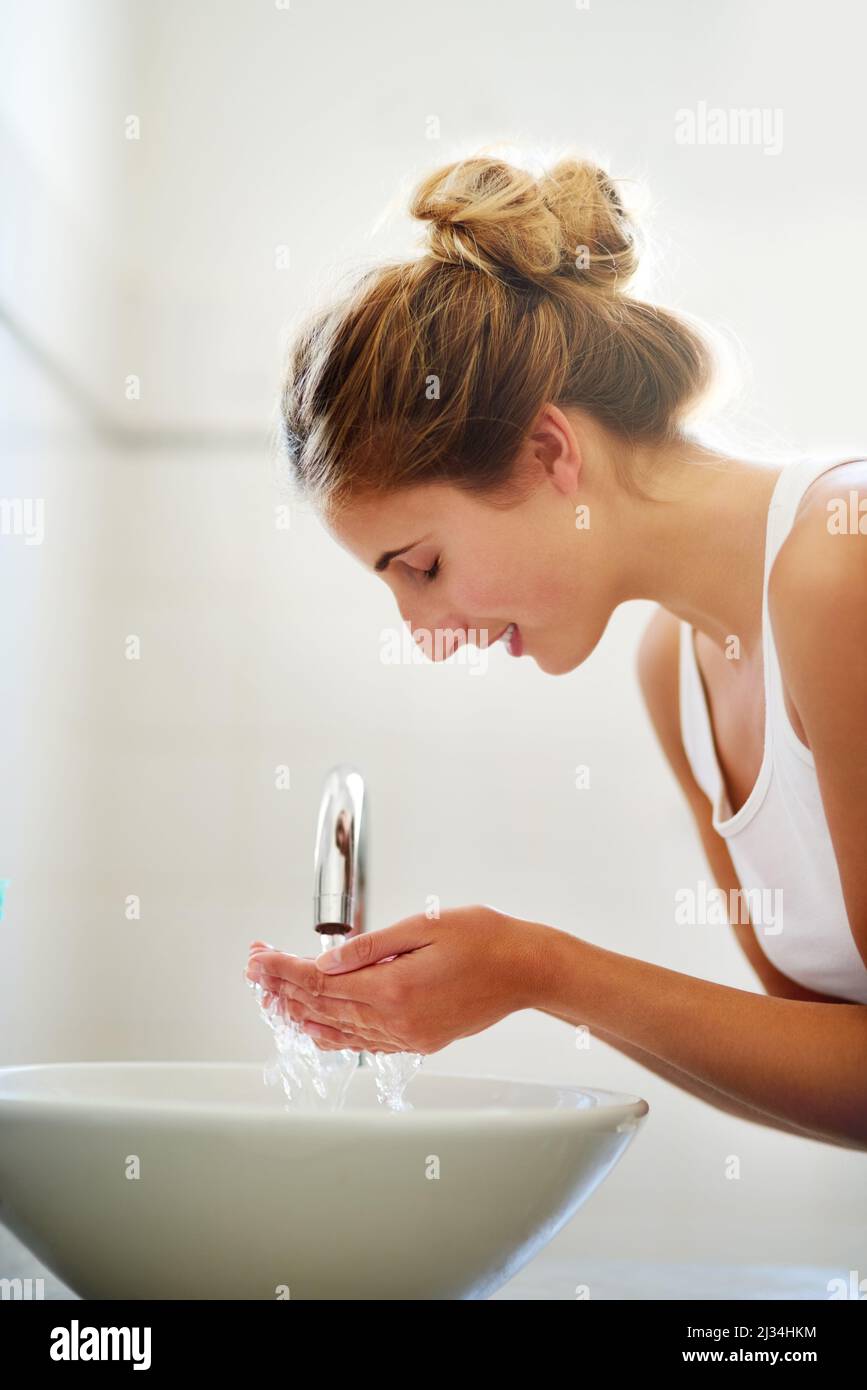 Clean skin is healthy skin. Shot of a beautiful young woman washing her ...