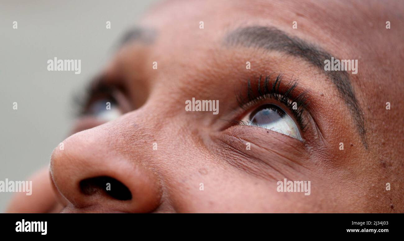 Faithful black woman praying feeling the presence of God closing eyes ...