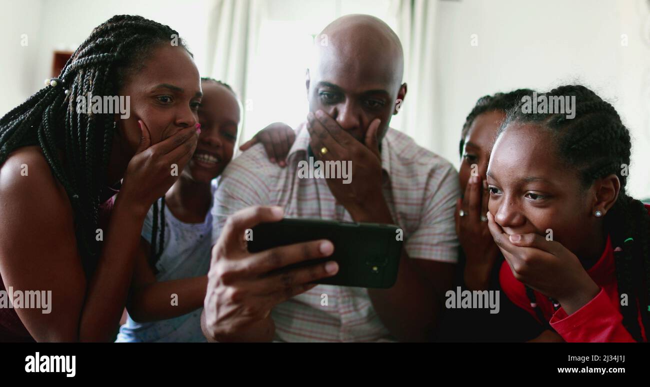 Family reaction in shock emotion looking at cellphone device news ...