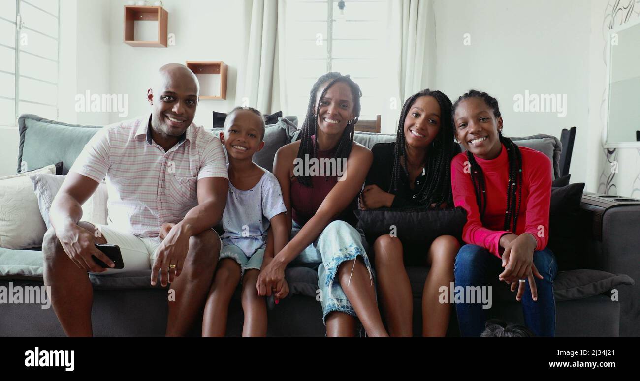 Family posing for photo at home couch, black African ethnicity parents ...