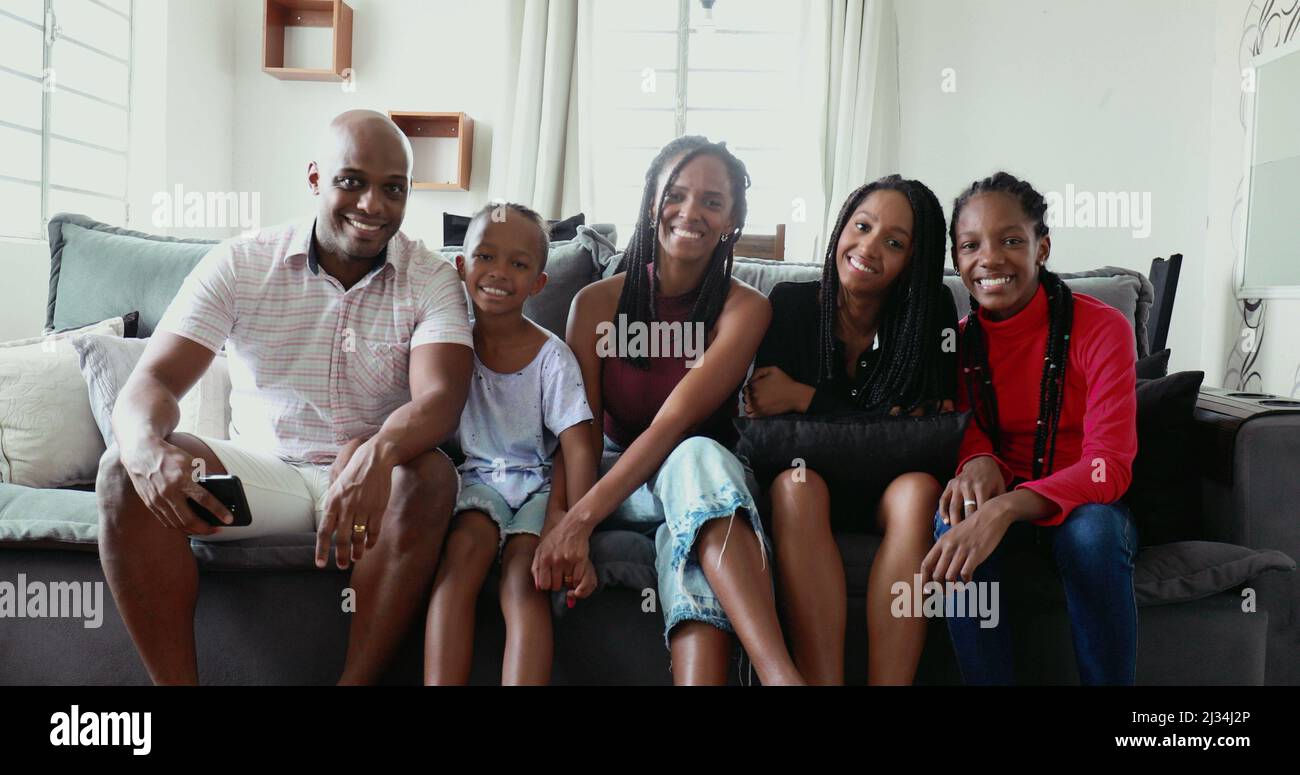 Family posing for photo at home couch, black African ethnicity parents ...