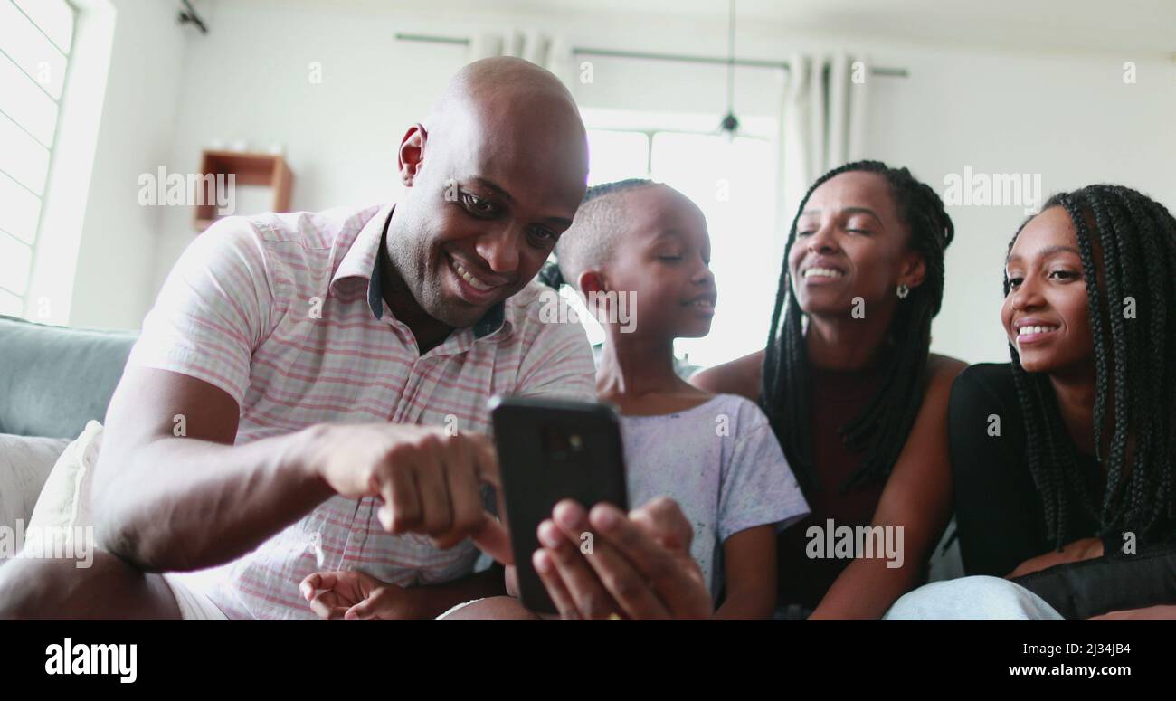 Father showing cellphone screen to children, family gathered togehet ...