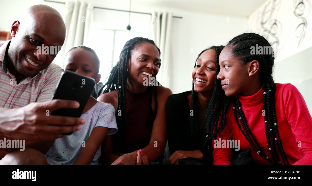 Happy family reviewing photo on smartphone device, black african ...